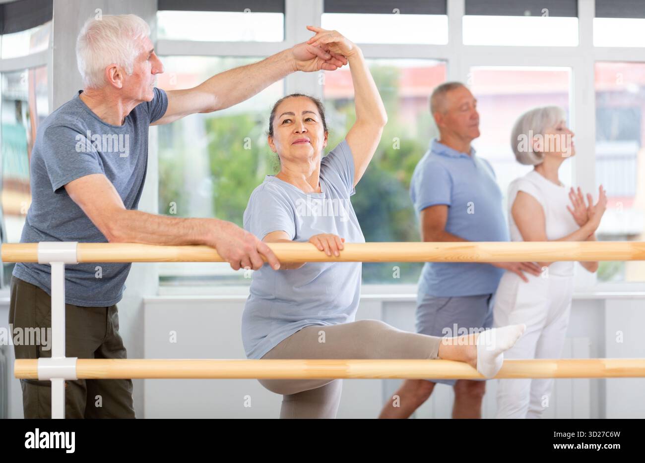Professional senior male ballet trainer teaching group of dancers ...