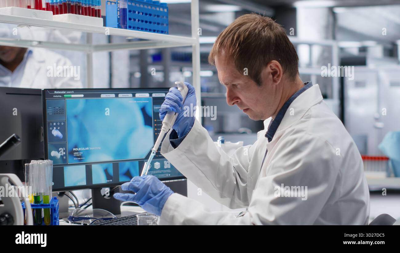 Male scientist handles pipette with droplet over jar during procedure ...