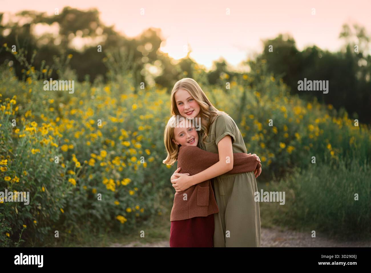 Sunset Photo of Sisters Hugging in a Field at Sunset Stock Photo - Alamy