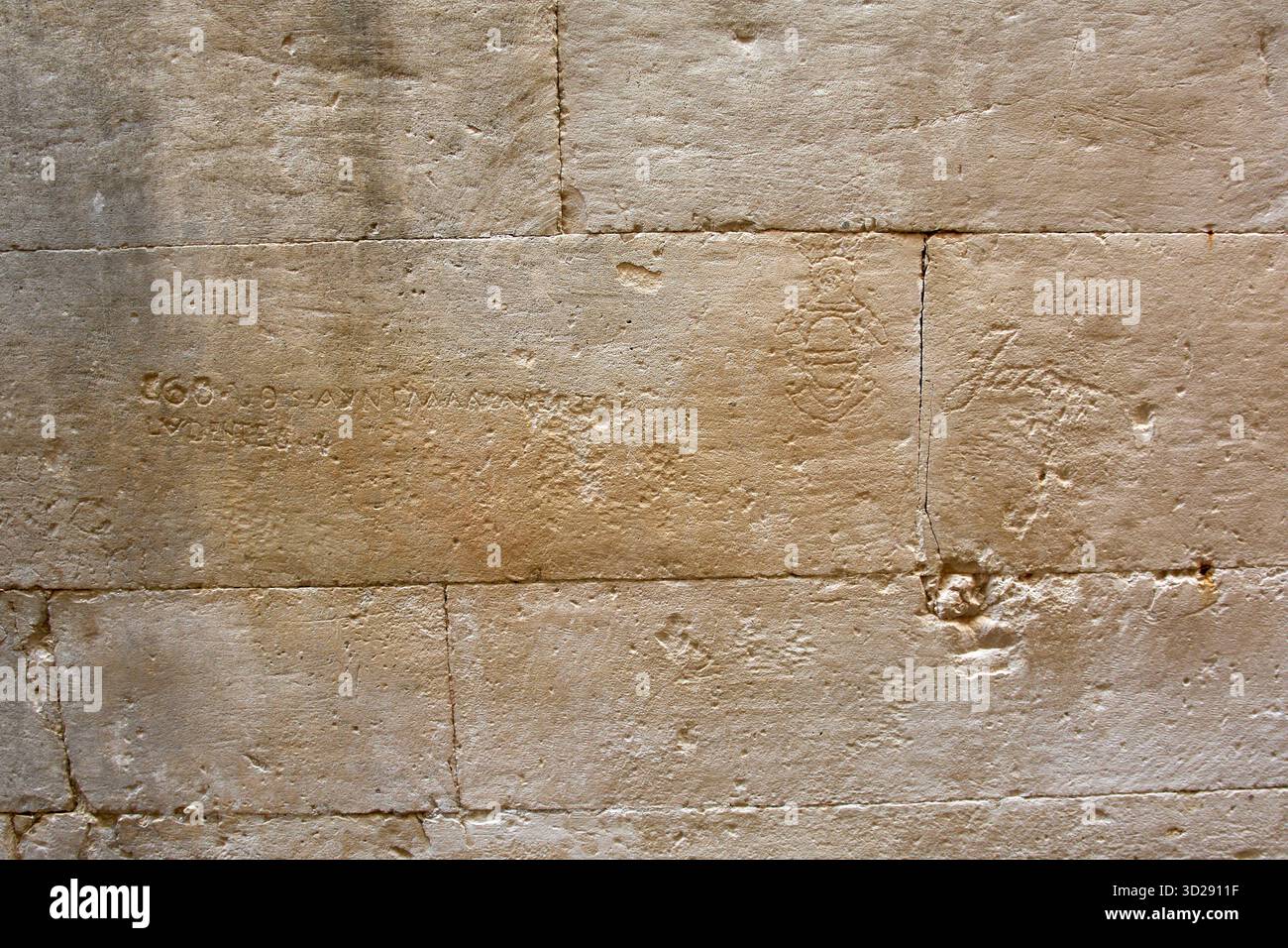 A detailed close-up of limestone blocks with ancient engravings. A coat ...