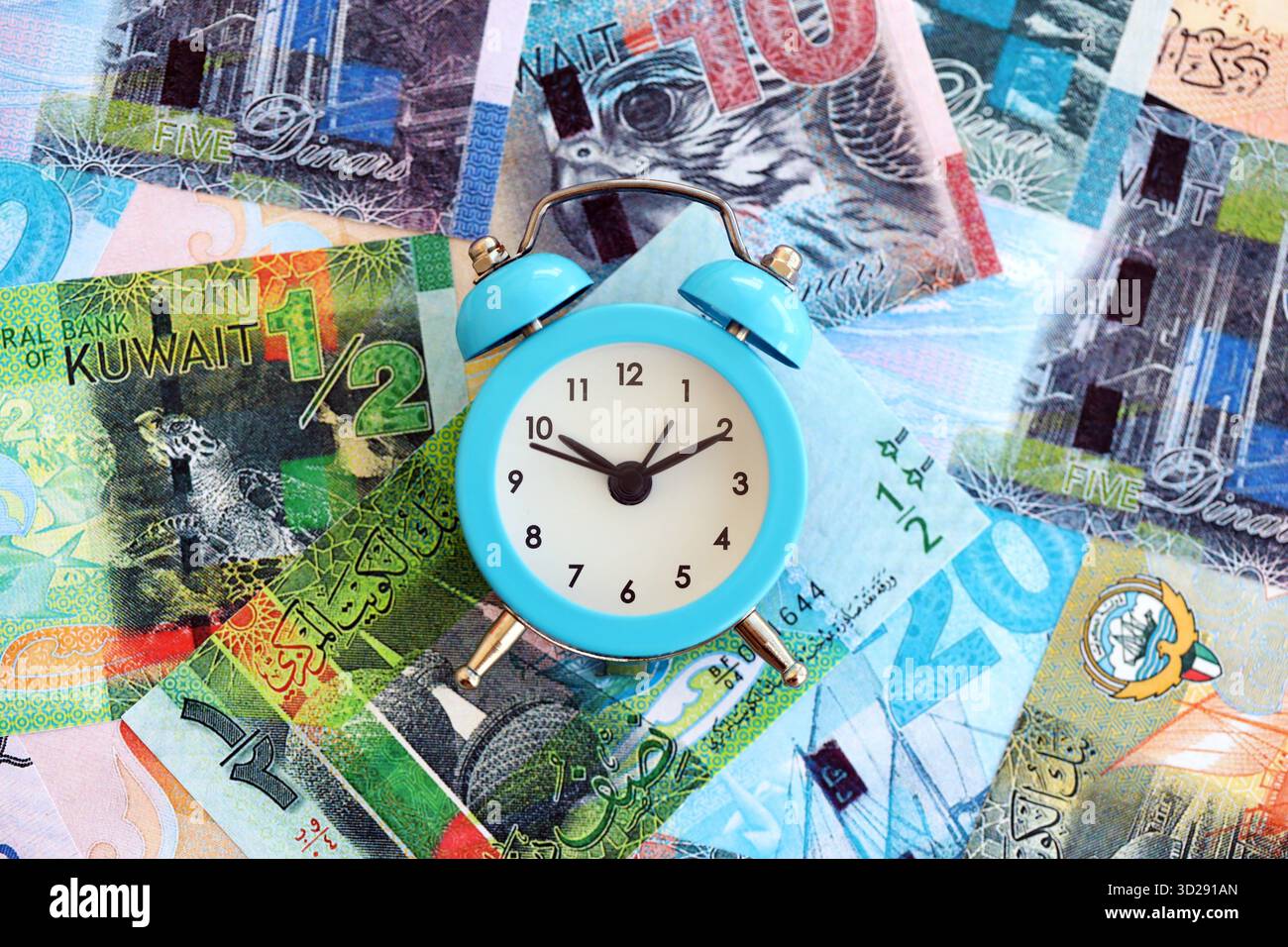 Kuwaiti dinar currency money bills and alarm clock close up. The ...