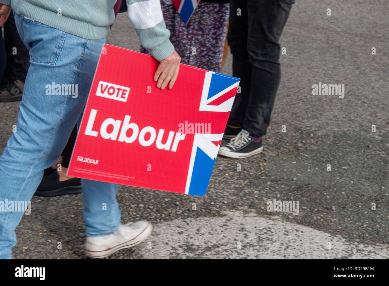 An activist holding a "Vote Labour" correx board Stock Photo - Alamy