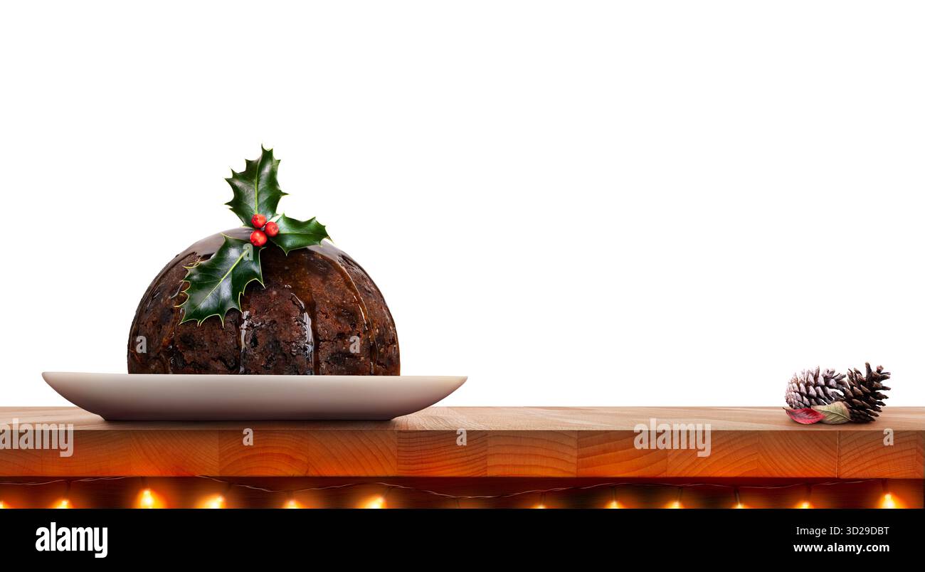 A traditional Christmas pudding on a square plate with a sprig of holly ...