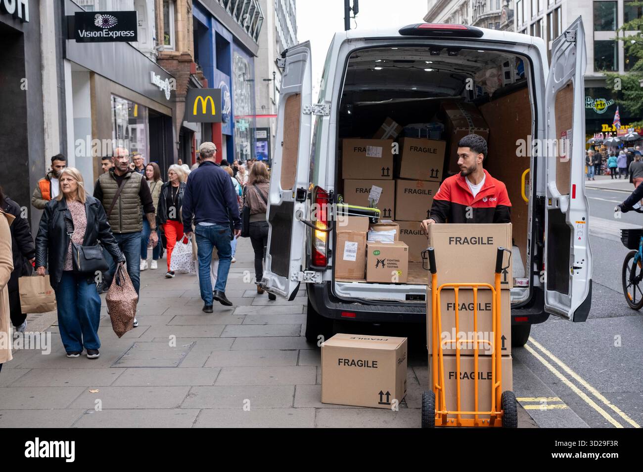 DPD Delivery man carefully sorts through boxes marked as fragile in the ...