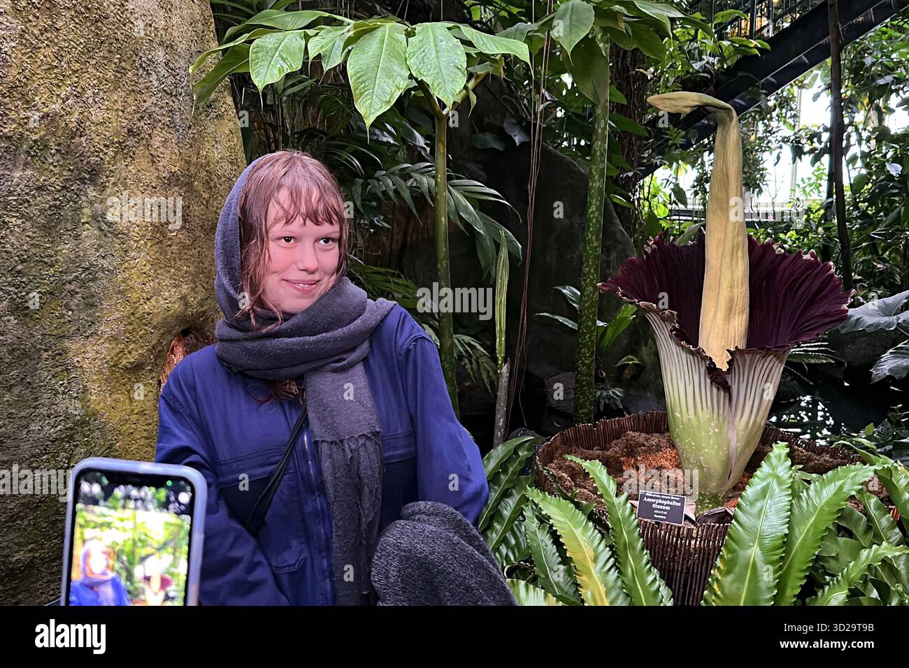 Garden visitor Rhea Fitzpatrick poses for a photo with a blooming ...