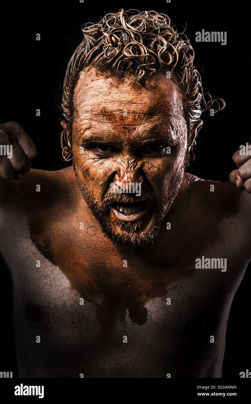 Anger man, Warrior young covered in mud Stock Photo - Alamy