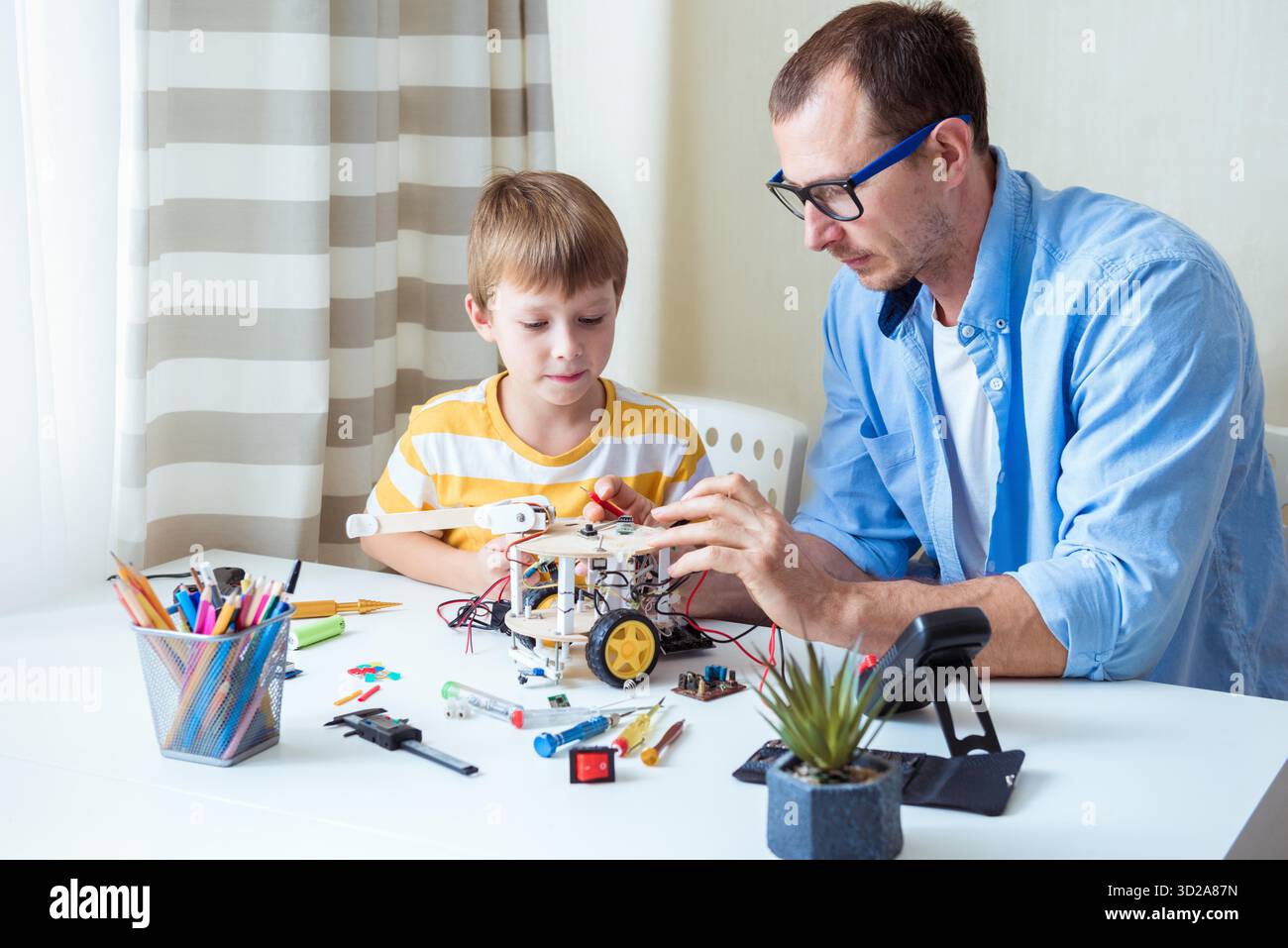 Stem education. School boy male teacher working on project, making diy ...