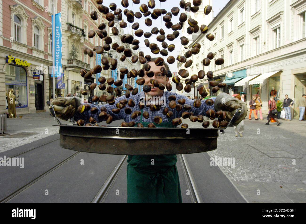 a chestnut vendor roasting chestnuts, delicious edible nuts with brown ...
