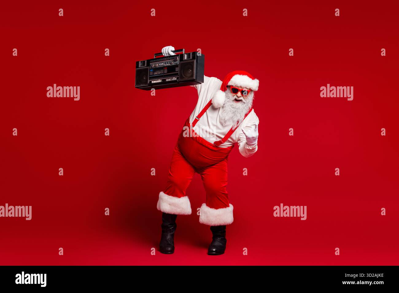 Santa with a retro boombox dances in a red studio creating festive ...