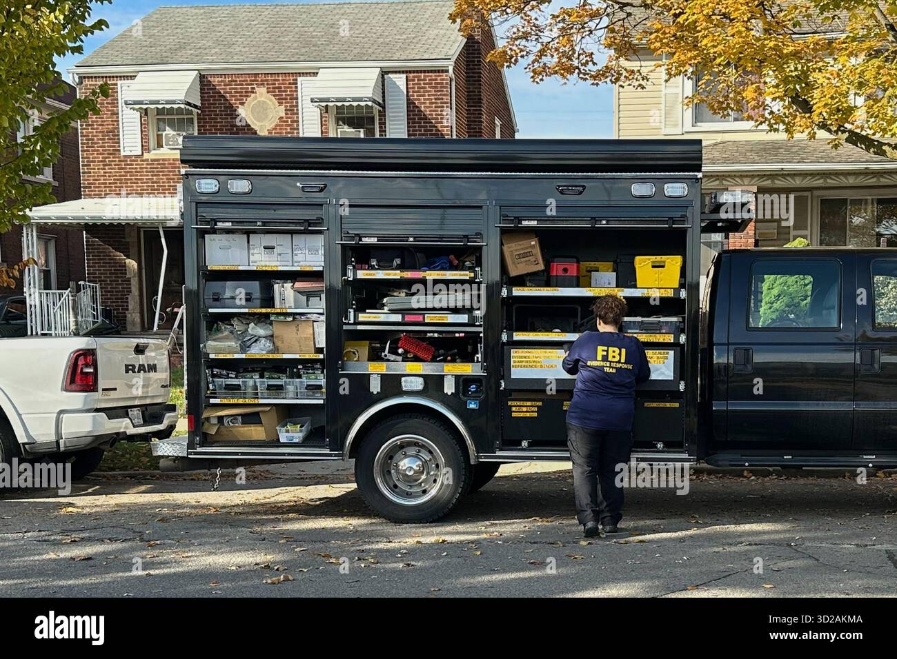 An FBI agent stands by an Evidence Response Team truck outside a home ...