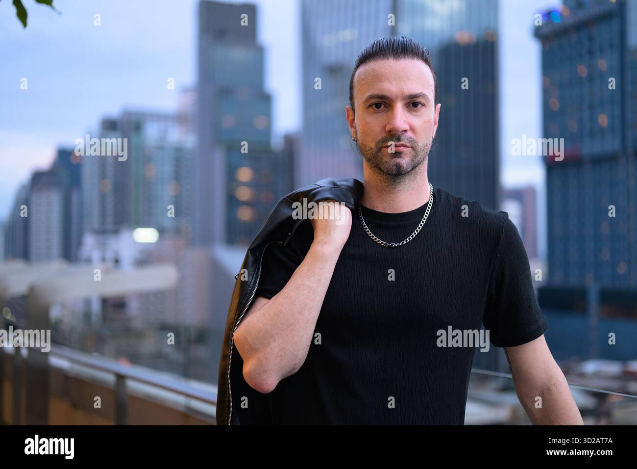 Handsome man wearing black leather jacket on rooftop Stock Photo - Alamy