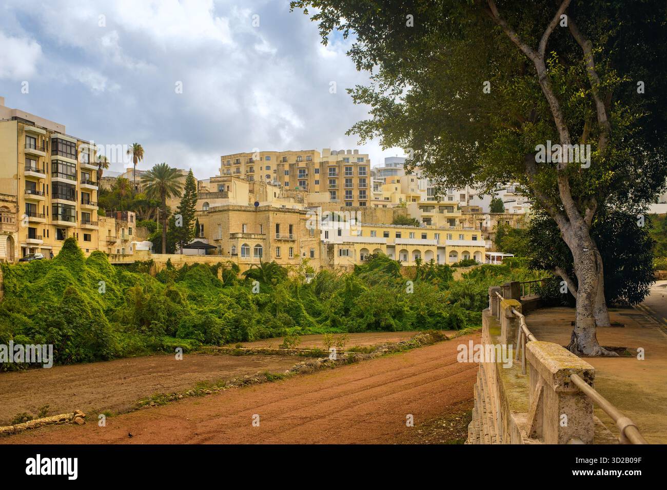 Cultivated garden plots with plowed soil surrounded by lush greenery ...