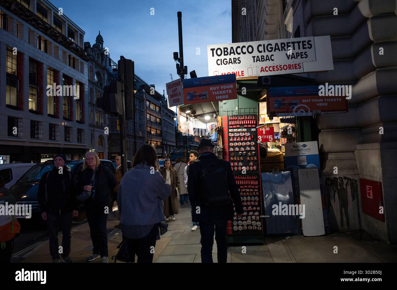 Pedestrians pass a tobacco and cigarettes booth sitting on the corner ...