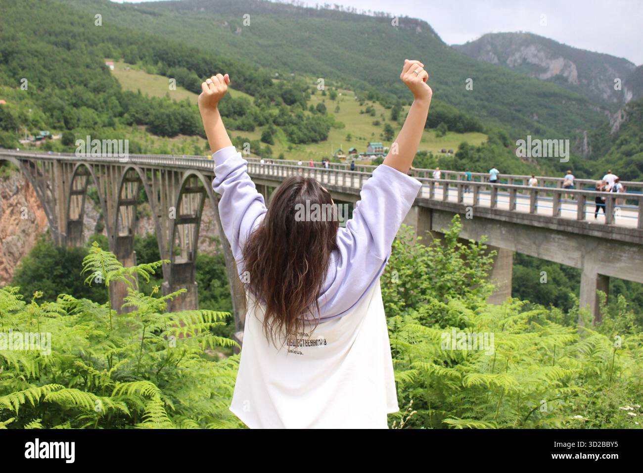 A traveler raising her arms in celebration while facing the Đurđevića ...
