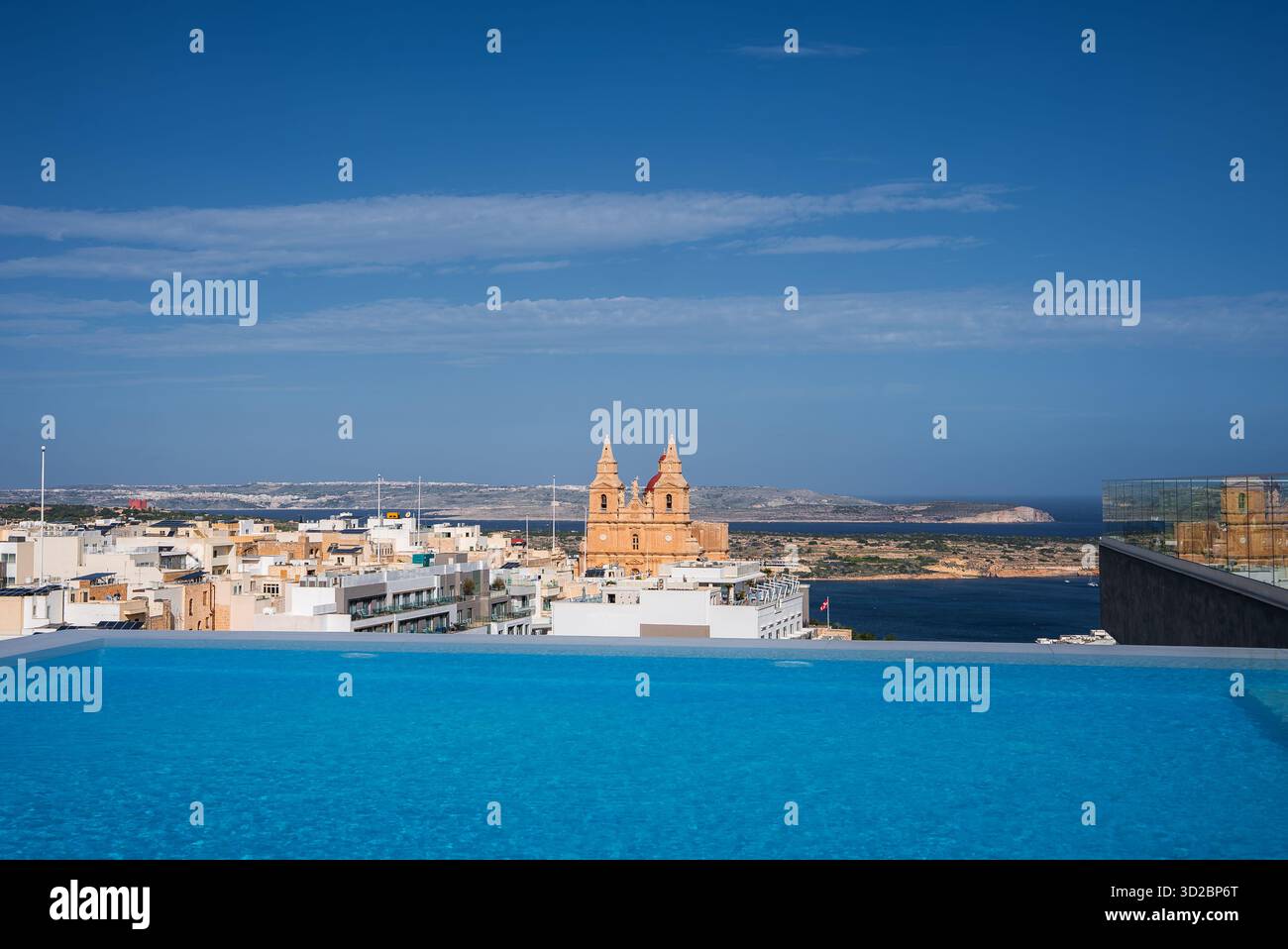 Rooftop infinity pool view of Mellieha and parish church in Malta Stock ...