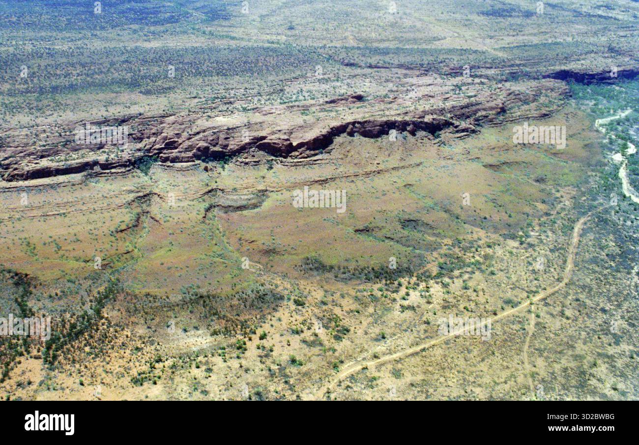 Aerial view of a long rocky ridge in the Australian outback, surrounded ...