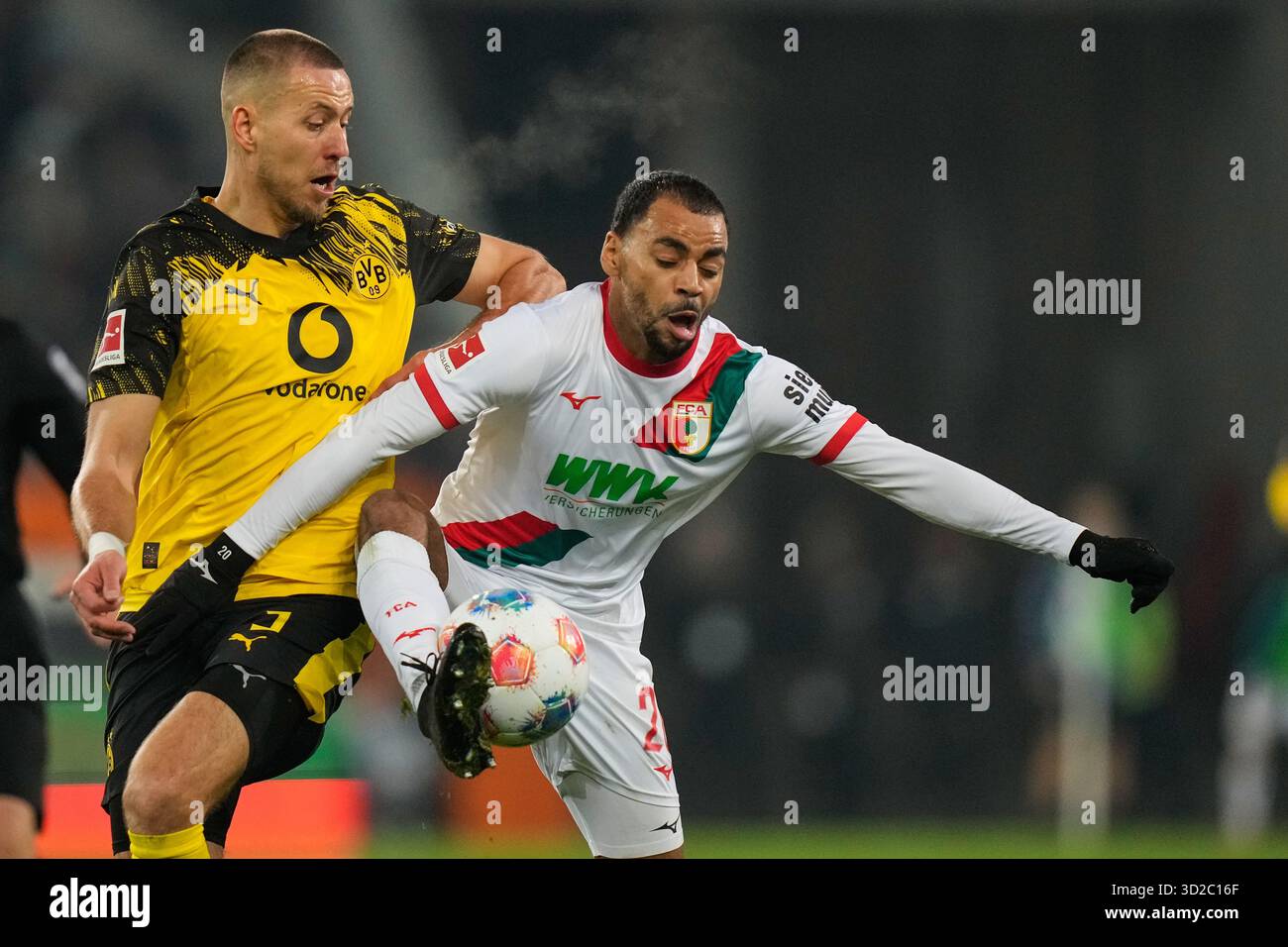 Augsburg's Alexis Claude-Maurice, right, challenges for the ball with ...