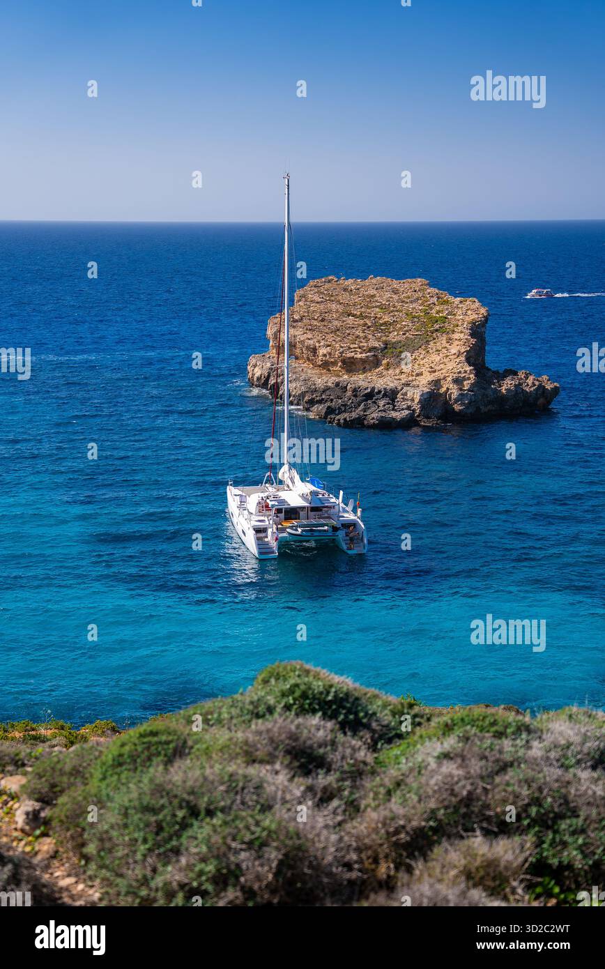 White catamaran at anchor by Blue Lagoon stacks, Comino, Malta Stock ...