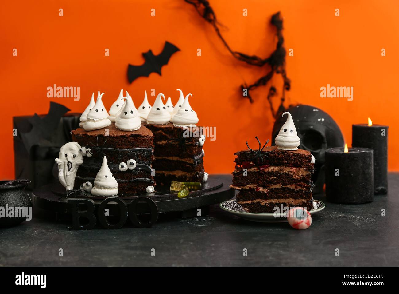 Tasty Halloween cake with ghosts, eyes and word BOO on black table ...