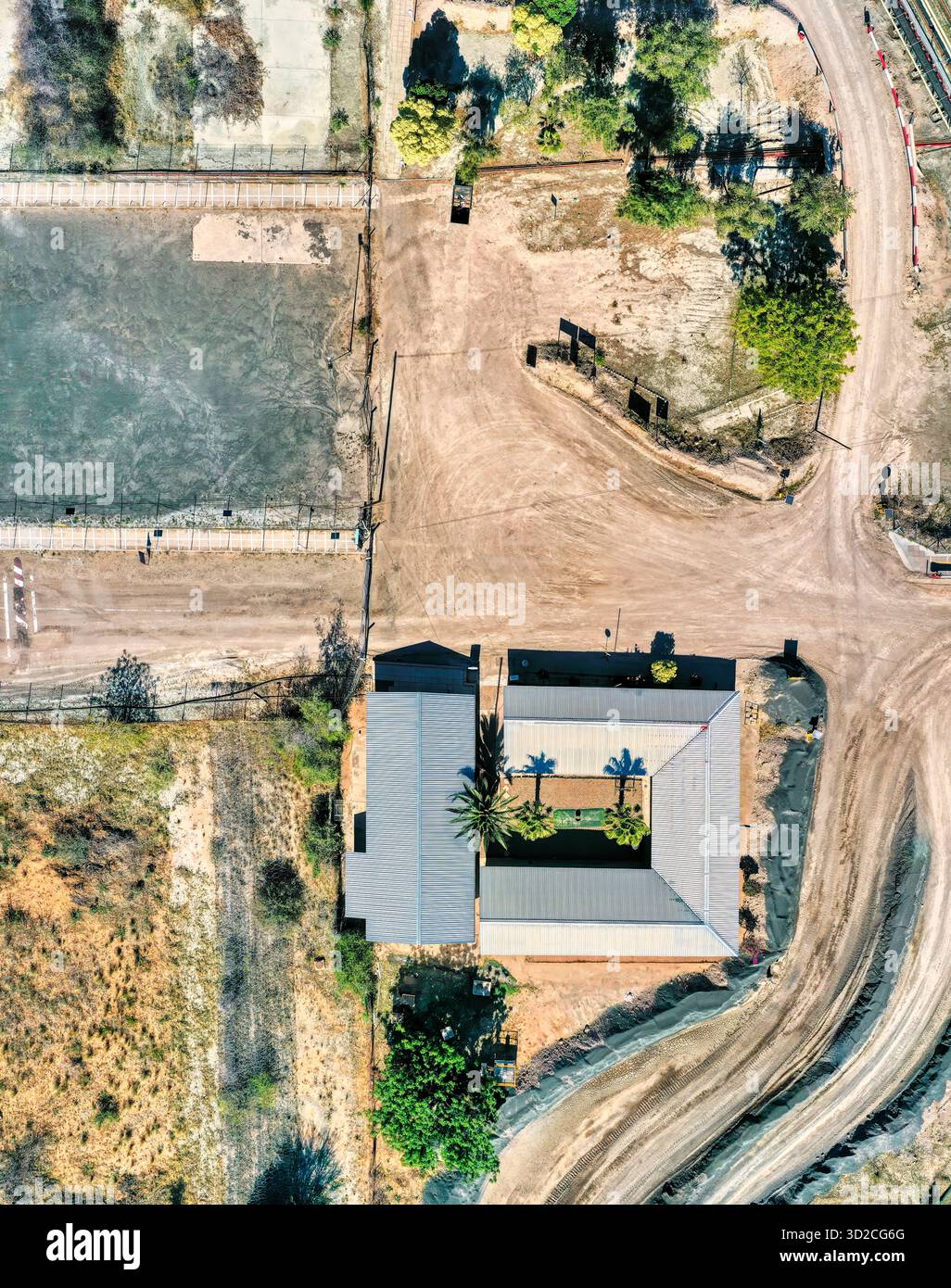 building with metal sheet roof barracks on industrial land, dirt roads ...