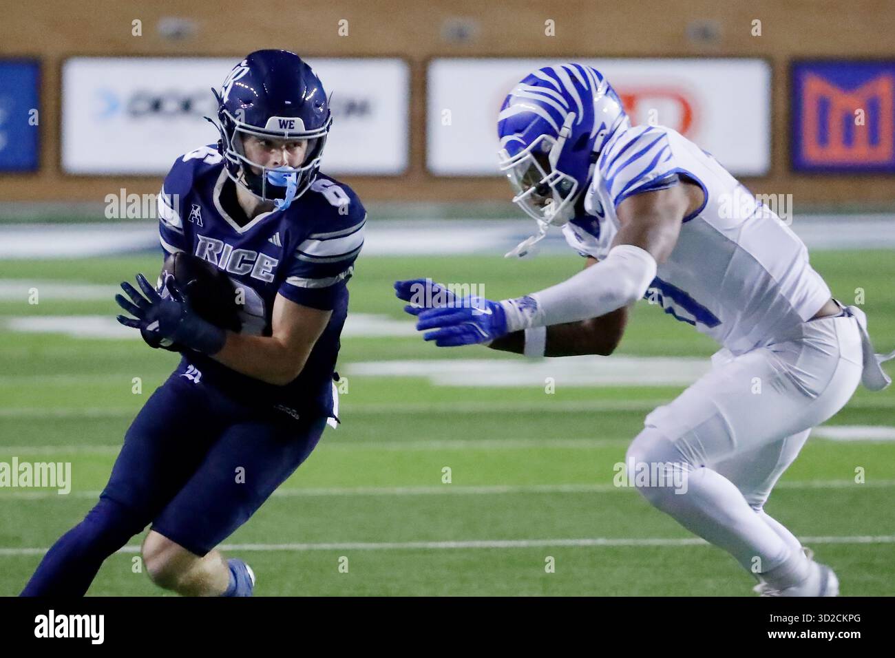 Rice quarterback Lucas Scheerhorn, left, makes a gain before contact ...