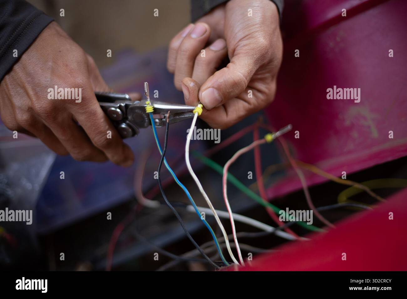 selective focus The hands of a car mechanic are using pliers to clamp ...