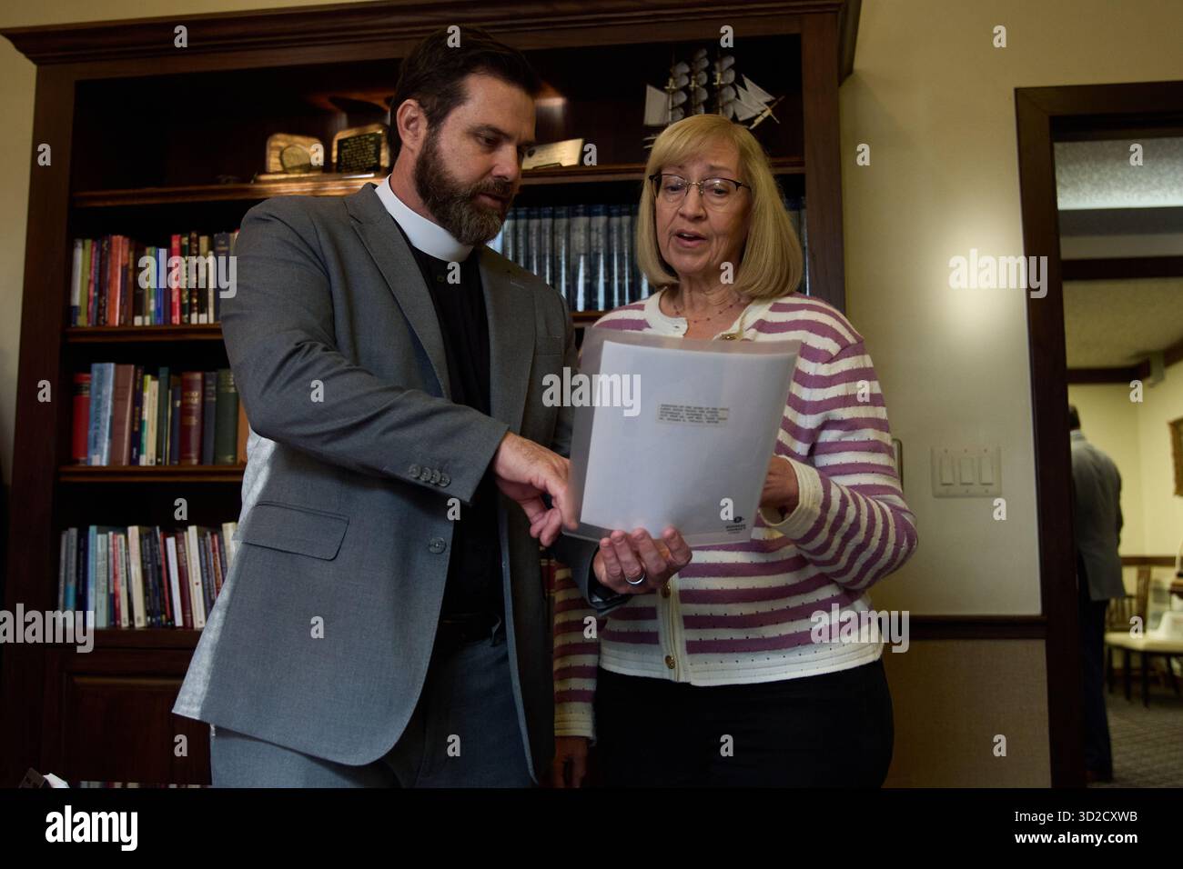 Pastor Todd Meyer, left, shows Bette Wisniowiecki an image of her father, Rev. Richard Ingalls ...