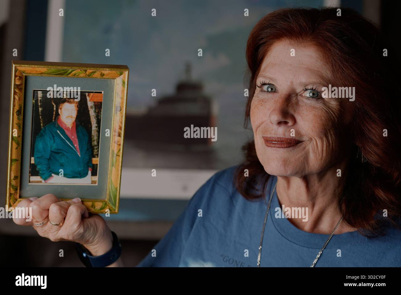 Deb Felder holds up a picture of her father who died on the Edmund ...