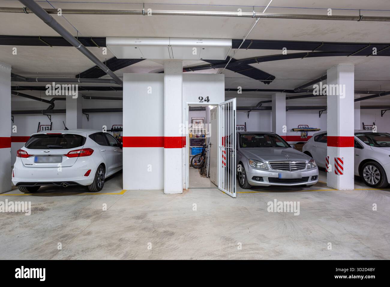 Subterranean parking garage with parked vehicles, numbered spaces, and ...