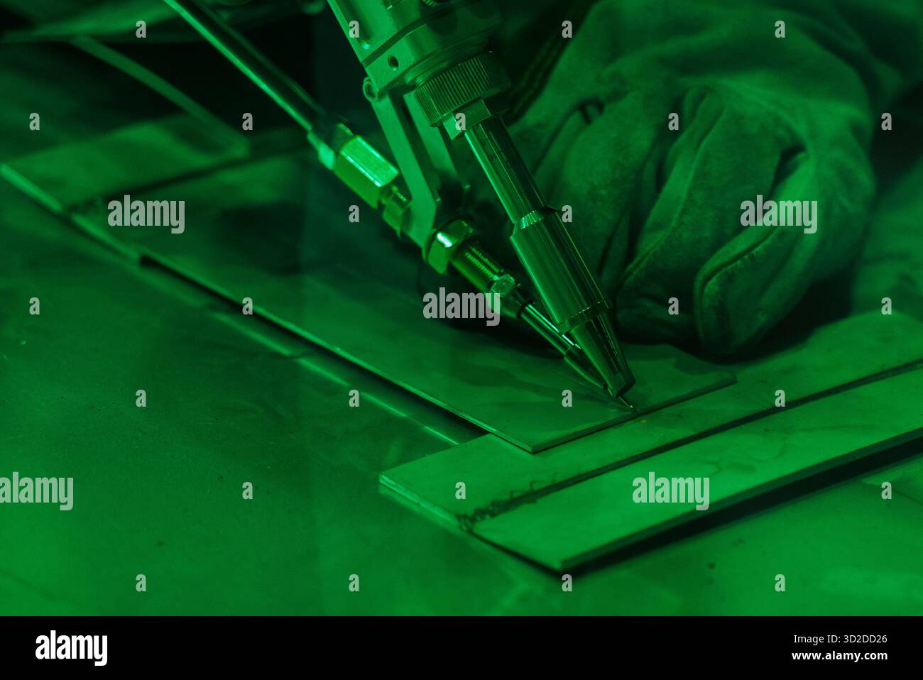 Close up of a human hand performing laser welding on metal, bright ...