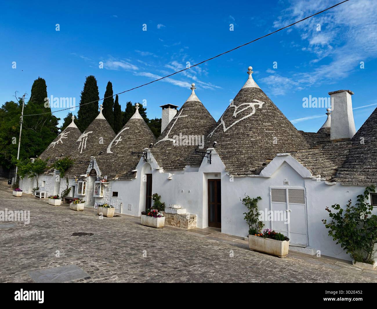 Traditional Trulli houses on a cobblestone street in Alberobello ...