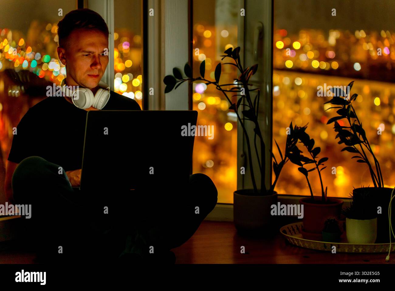 A young male developer is programming a code script late at night with ...