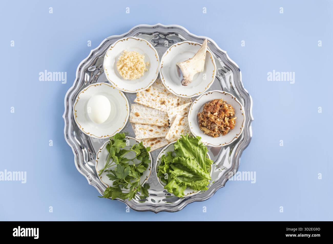 A silver plate with traditional Jewish treats for Passover. baked egg, lettuce, horseradish ...
