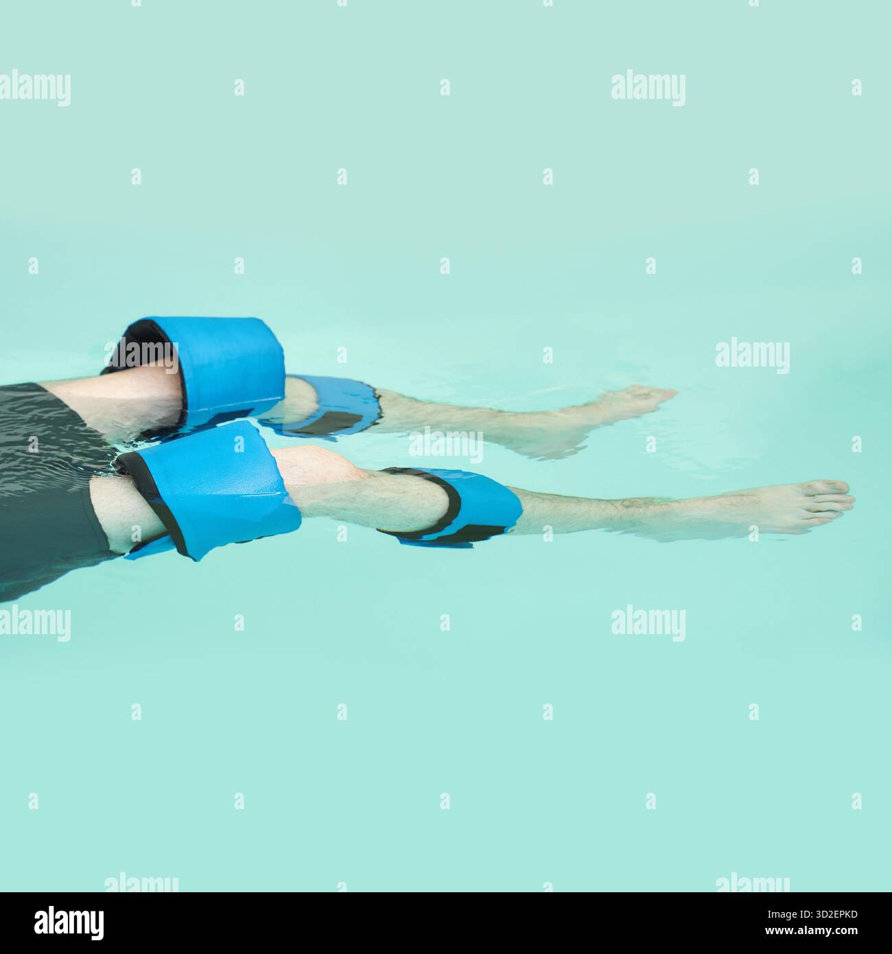 Aquatic therapy pool session with caucasian male using blue floatation ...