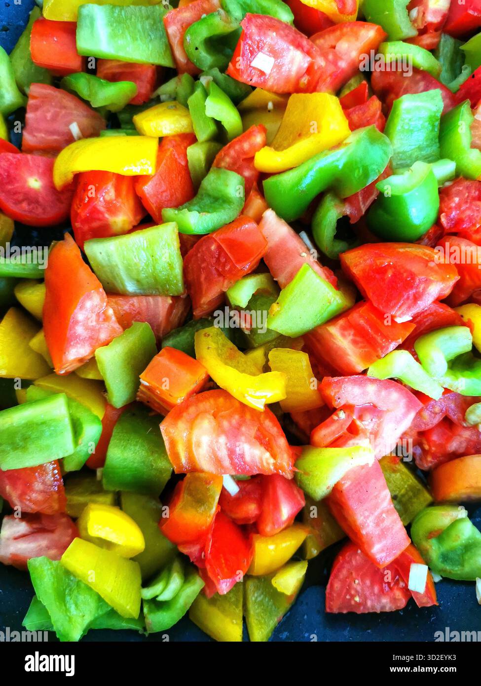 Chopped red, yellow, and green bell peppers mixed with diced tomatoes ...