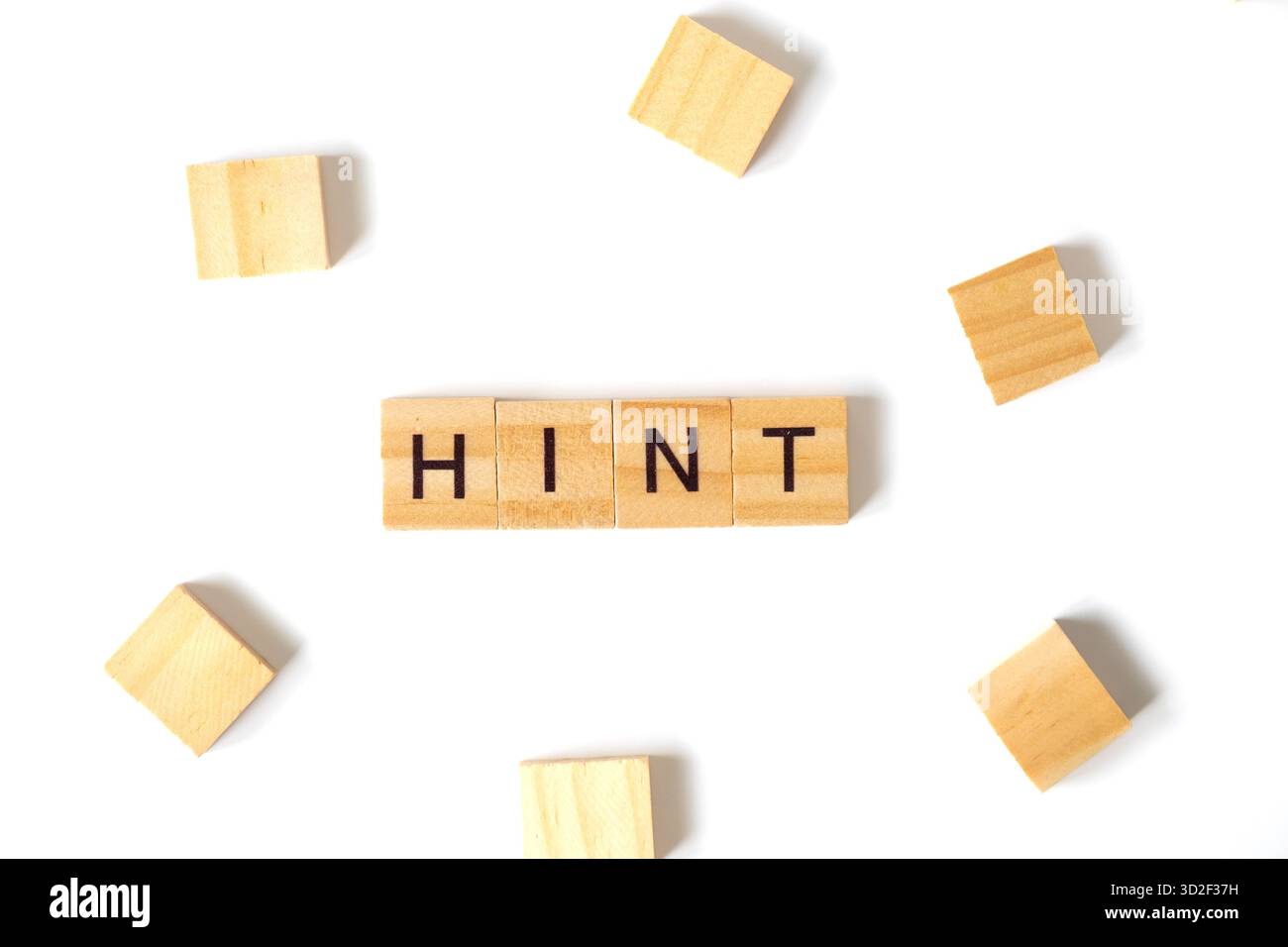 Minimalist image showing wooden letter tiles spelling 'HINT' surrounded ...