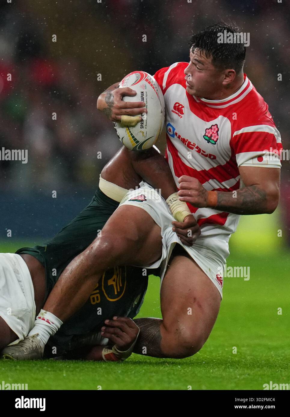 Japan's Charlie Lawrence, right, is tackled by South Africa's Siya ...