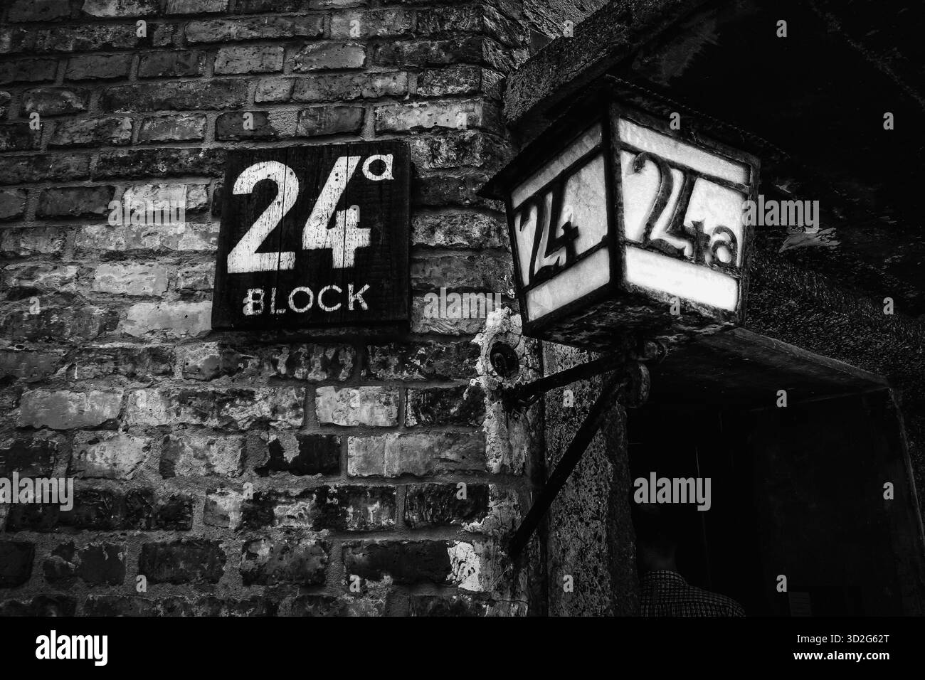 The sign for Block 24a and an exterior lamp are photographed in black ...