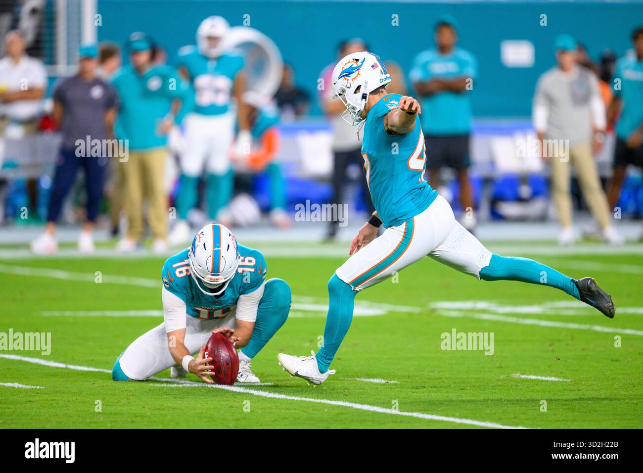 Miami Dolphins punter Jake Bailey (16) holds the ball as kicker Riley ...