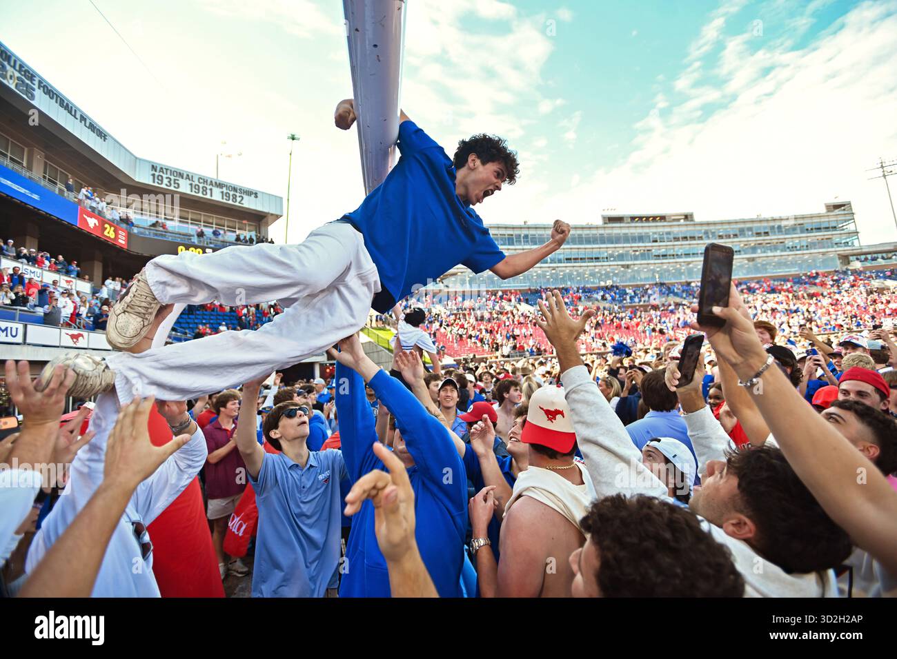 DALLAS, TX - AUGUST 30: A SMU Mustangs fans hangs off the goal post ...