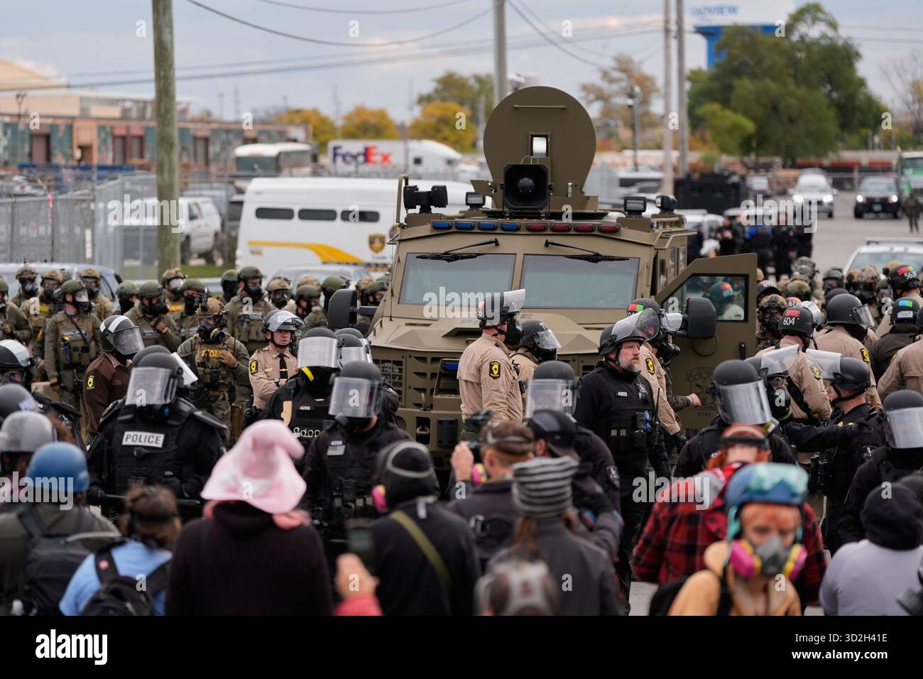 Law enforcement officers line up next to an Illinois state police SWAT ...
