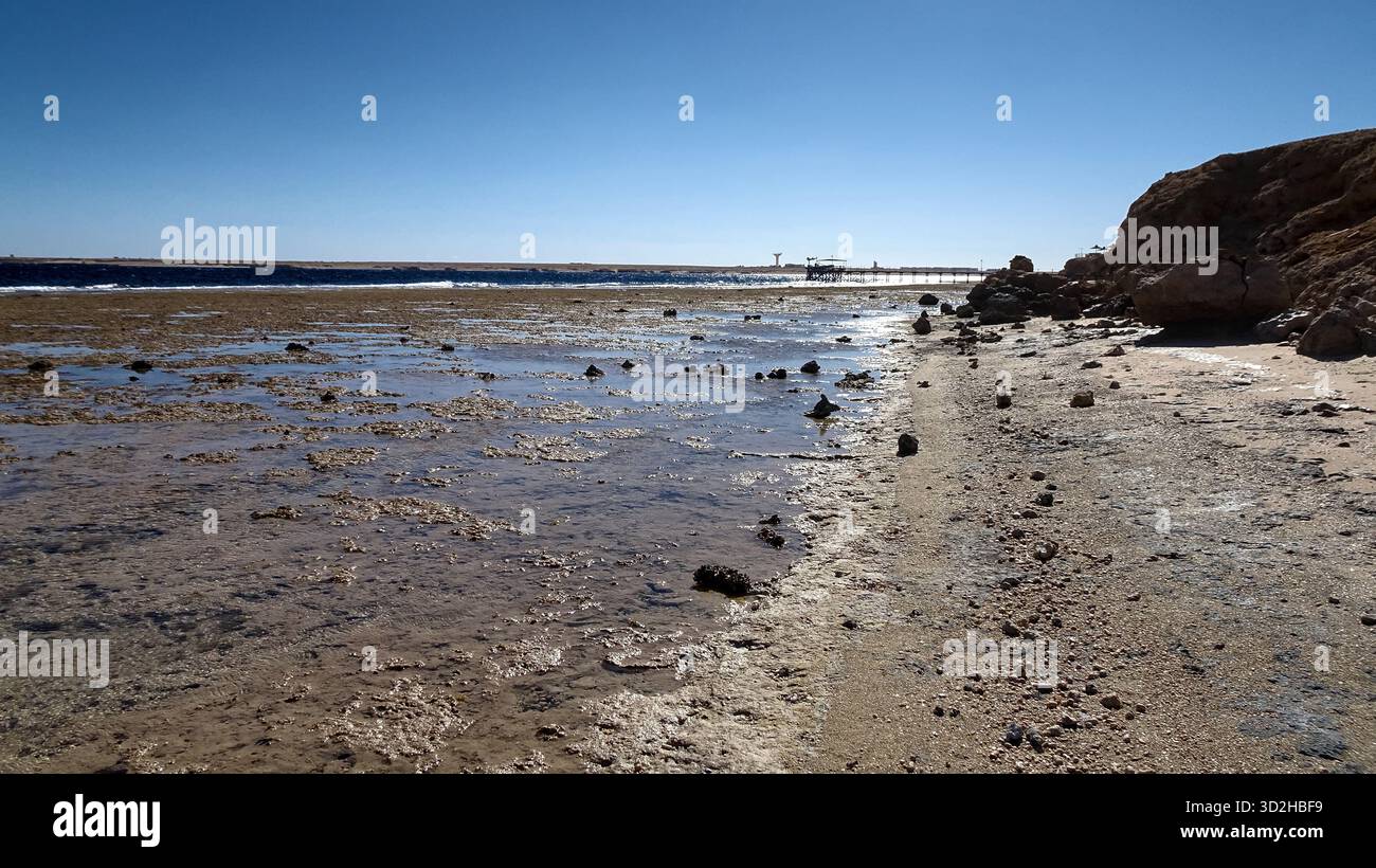 View of a wooden pier extending over the shallow reef flat at a hotel ...