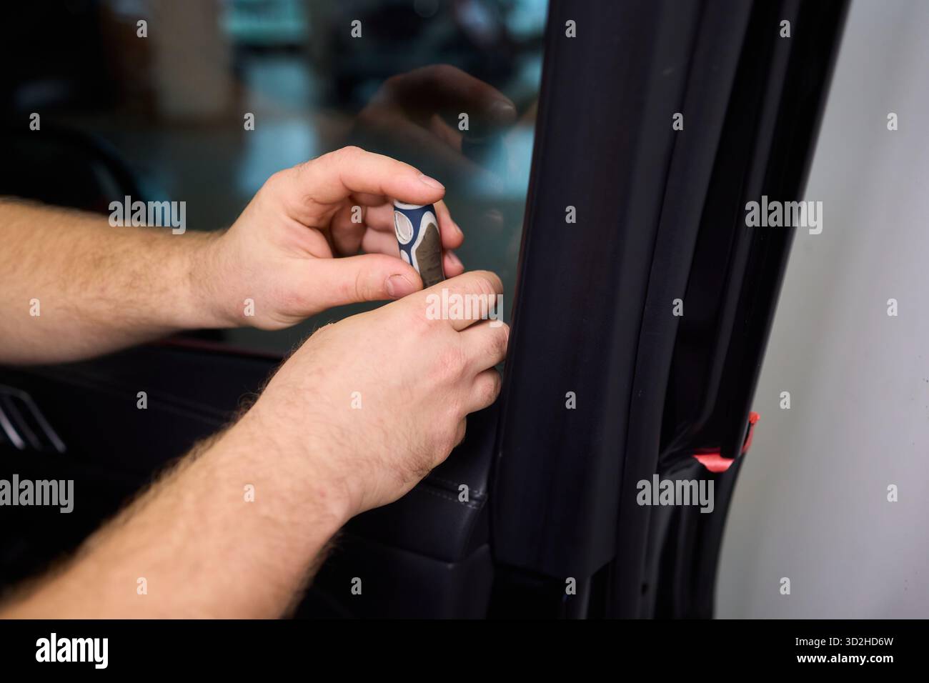 Skilled hands install a car door handle trim, highlighting ...