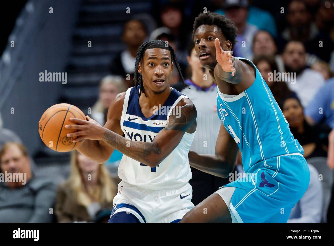 Minnesota Timberwolves guard Rob Dillingham, left, looks to pass ...
