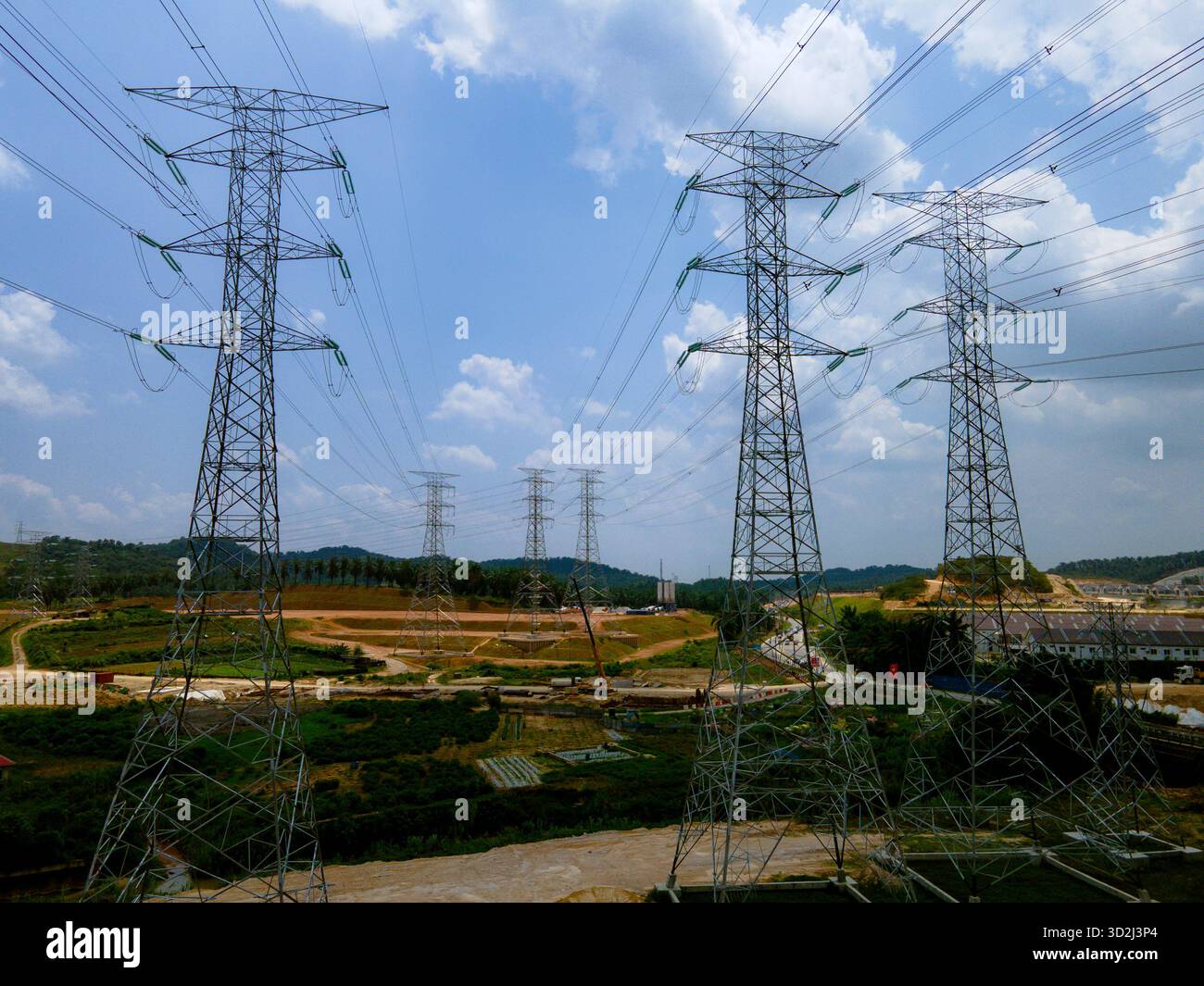 Aerial and ground view of high-voltage transmission towers in rural ...