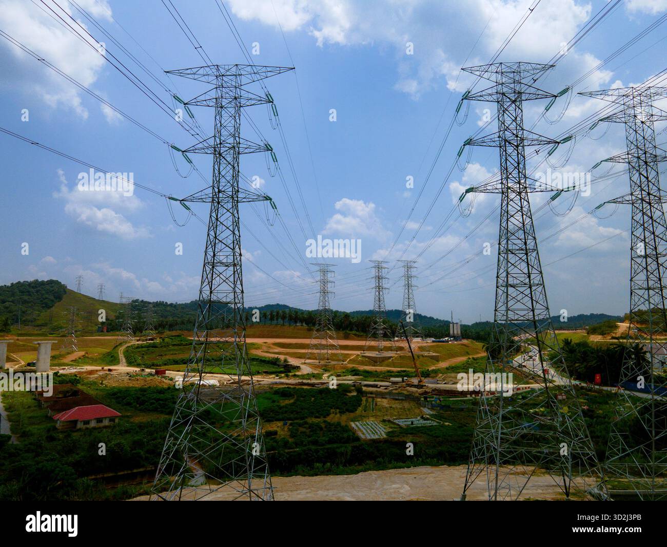 Aerial and ground view of high-voltage transmission towers in rural ...