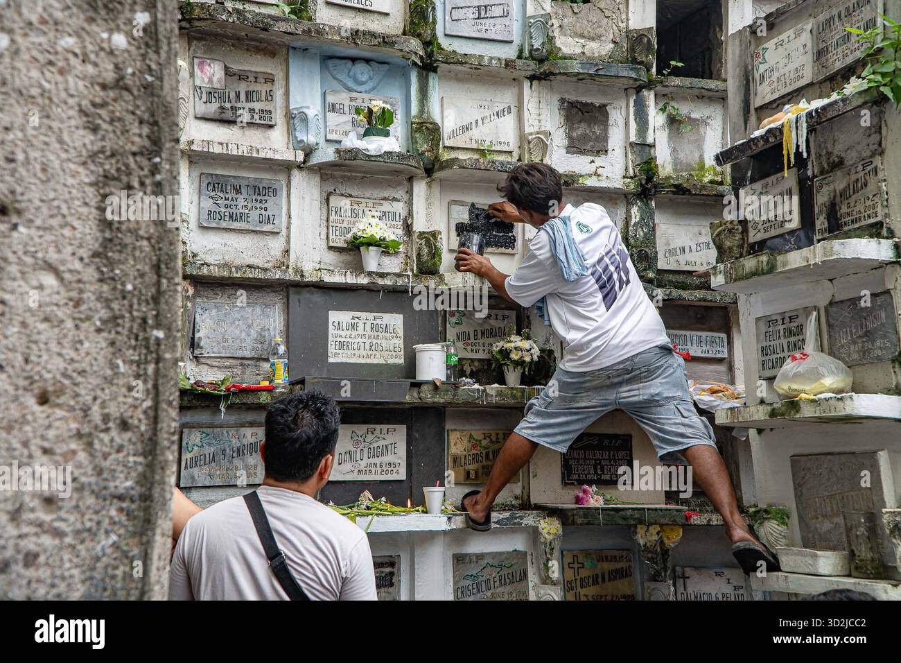 Manila, Manila, Philippines. 1st Nov, 2025. A man climbs atop tombs to ...