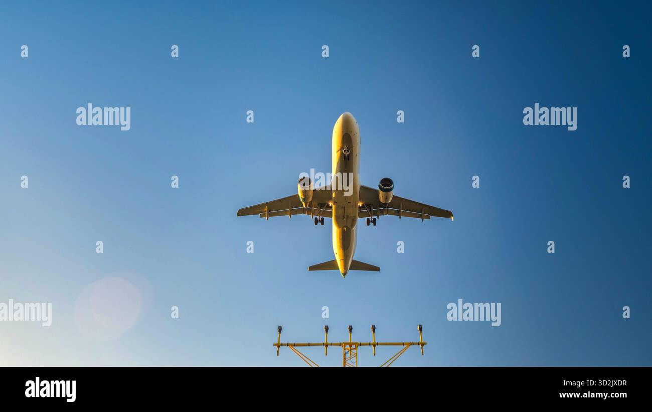The image shows a commercial airplane in flight, viewed from below ...