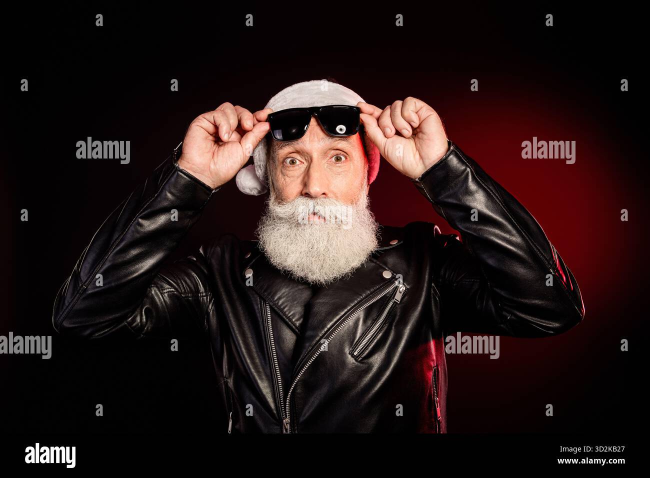 Cool Santa rocker in leather jacket lifts sunglass wearing a Santa hat ...