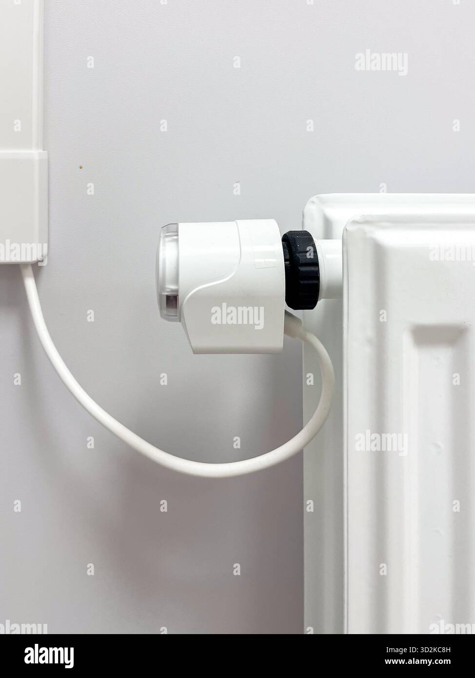 This image features a modern radiator valve with a temperature ...
